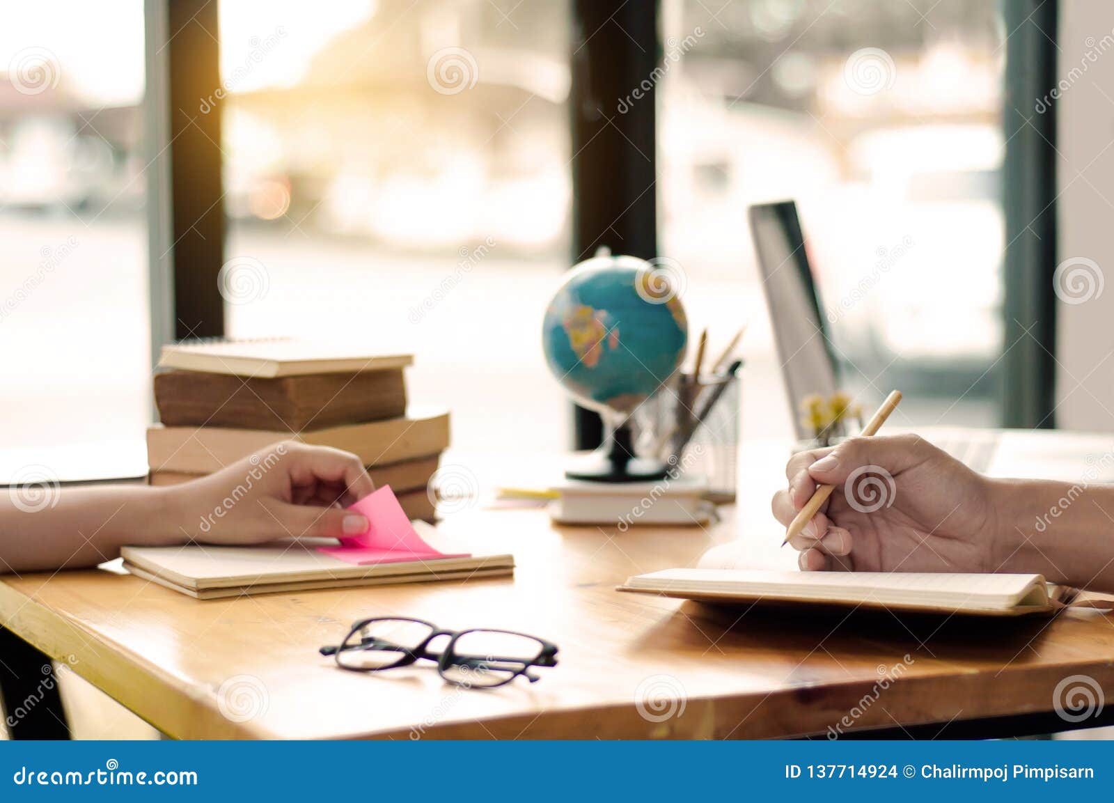 Two Confident Students Doing Homework Together while Sitting at the ...