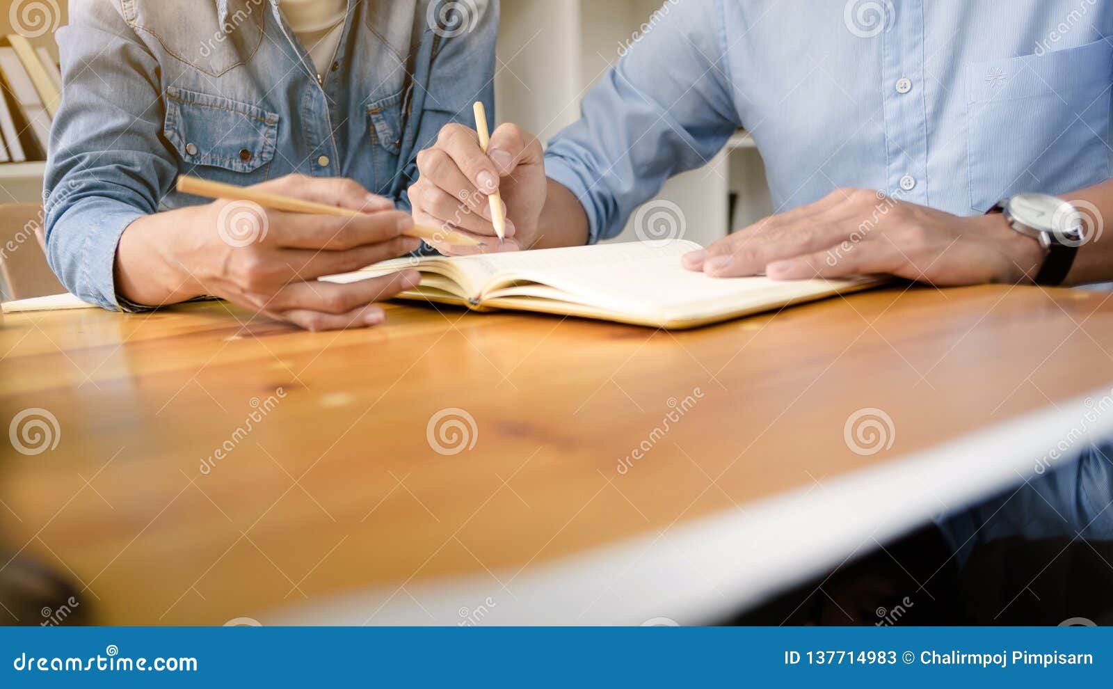 Two Confident Students Doing Homework Together while Sitting at the ...