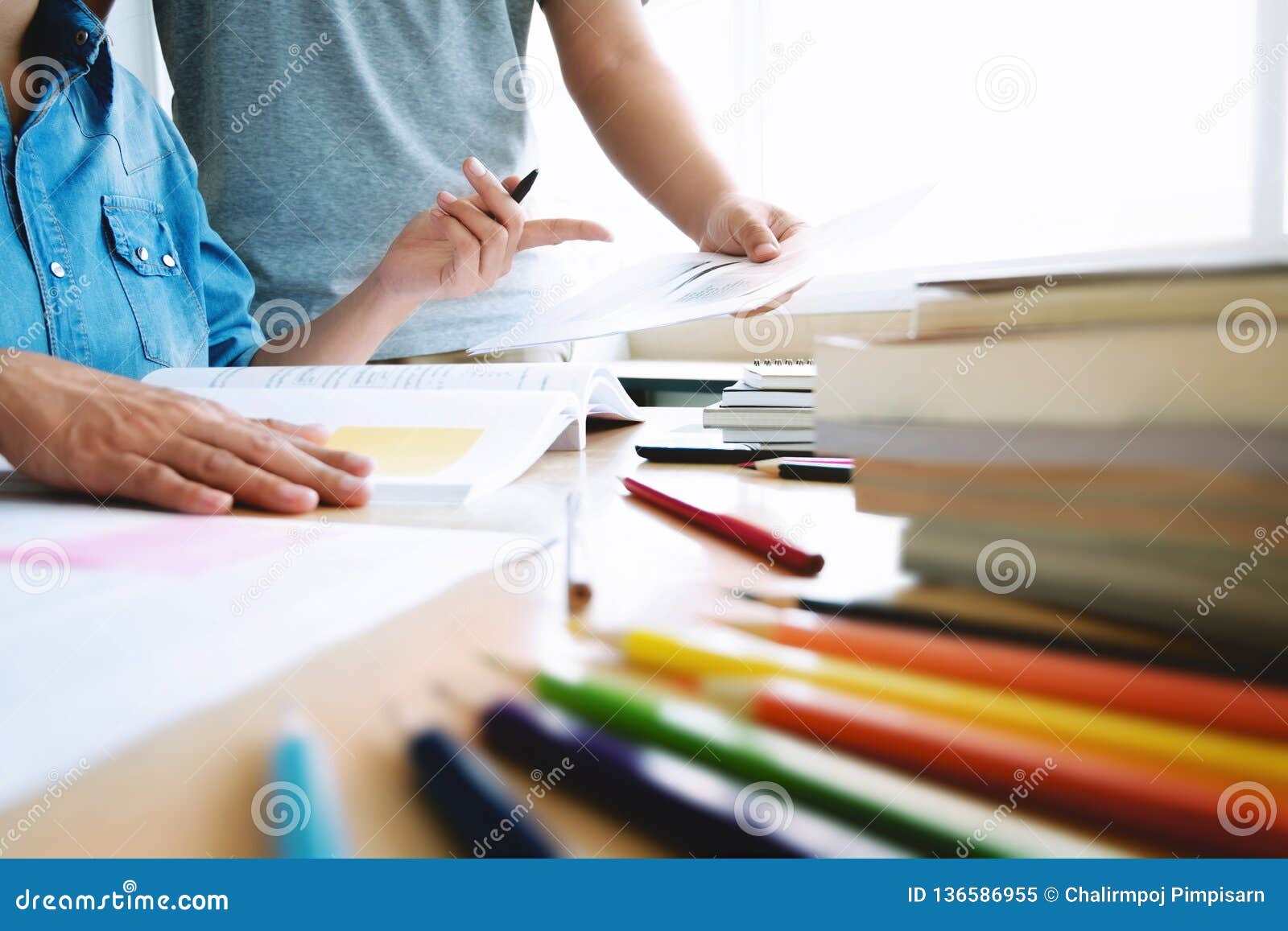 Two Confident Students Doing Homework Together while Sitting at the ...