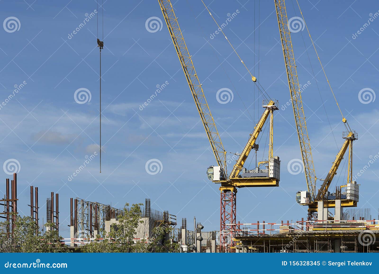 Two Construction Cranes at a Construction Site. Tall Crane on a Blue ...
