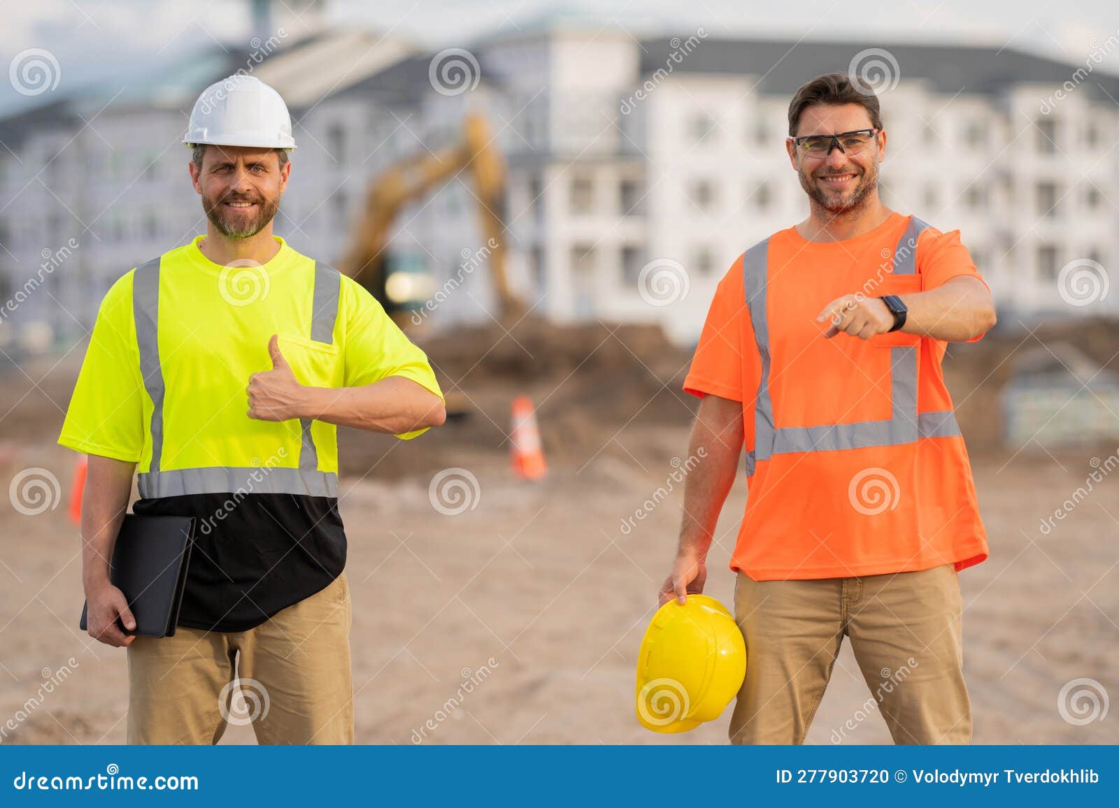 Two Construction Site Workers in Helmet Work Outdoors. Builders Workers ...