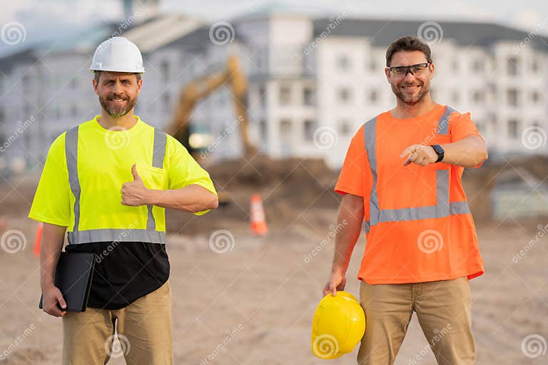 Two Construction Site Workers in Helmet Work Outdoors. Builders Workers ...