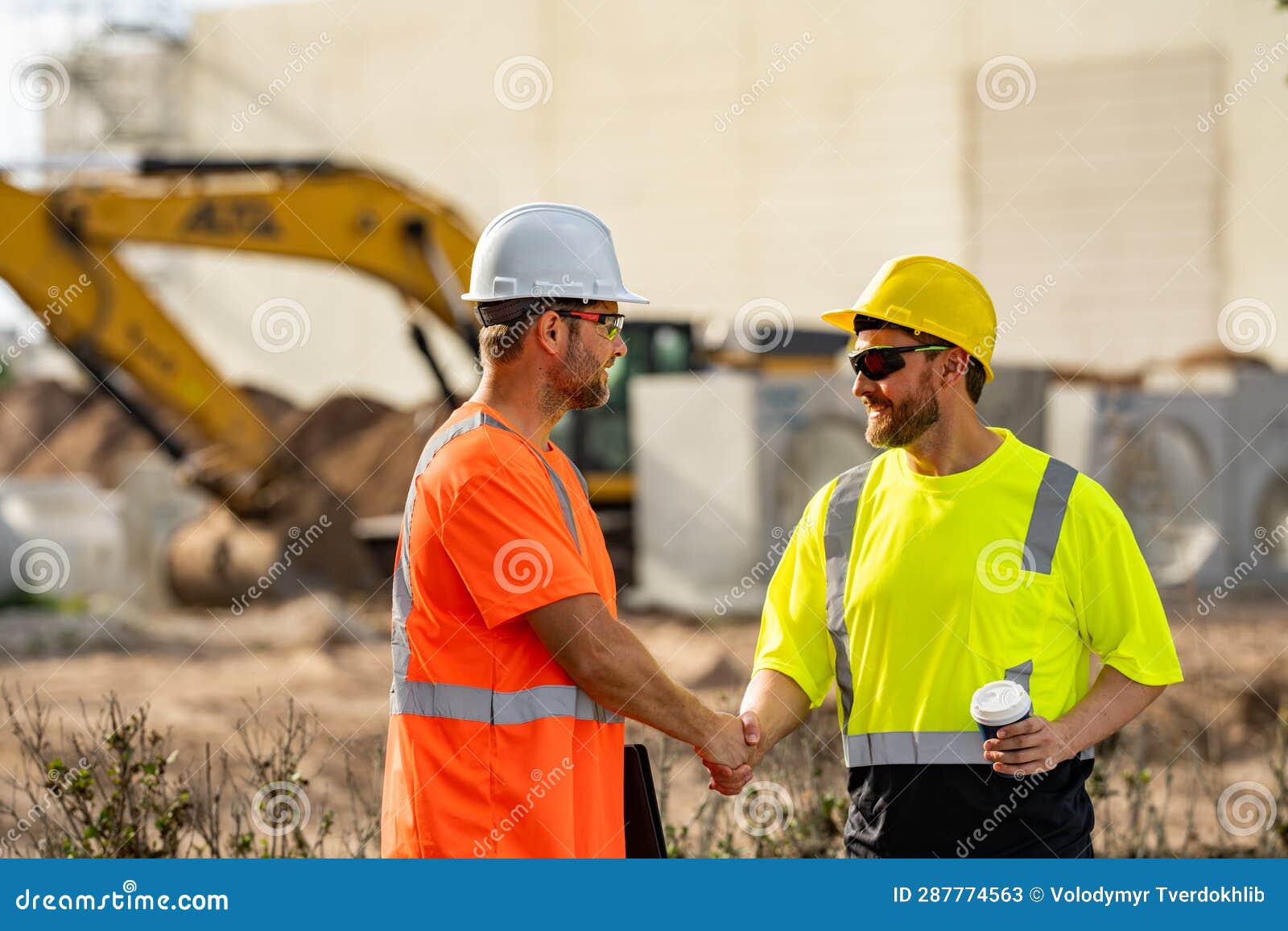 Two Construction Site Workers in Helmet Work Outdoors. Builders Workers ...