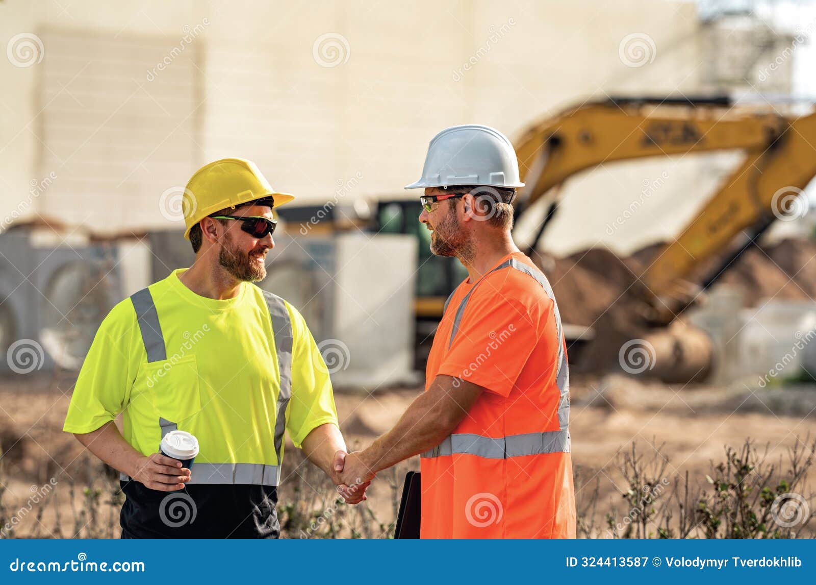 Two Construction Site Workers in Helmet Work Outdoors. Builders Workers ...
