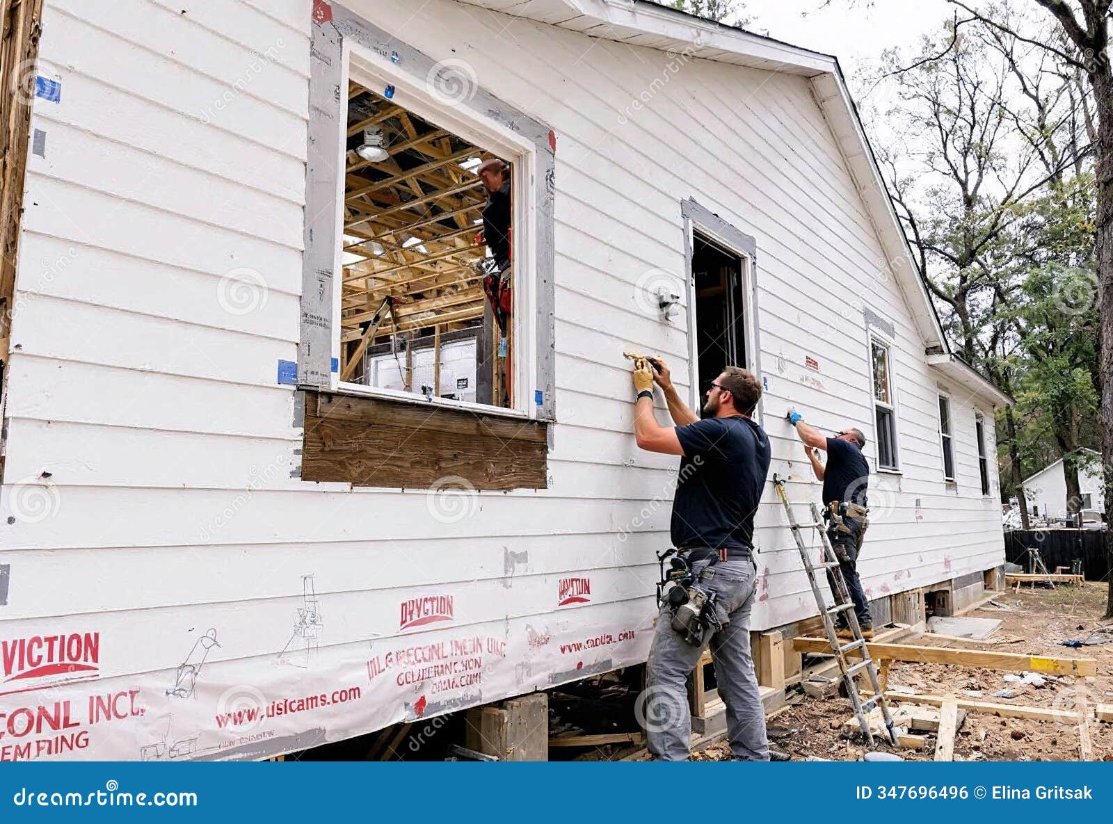 Construction Workers Install Siding on a Residential Building during ...