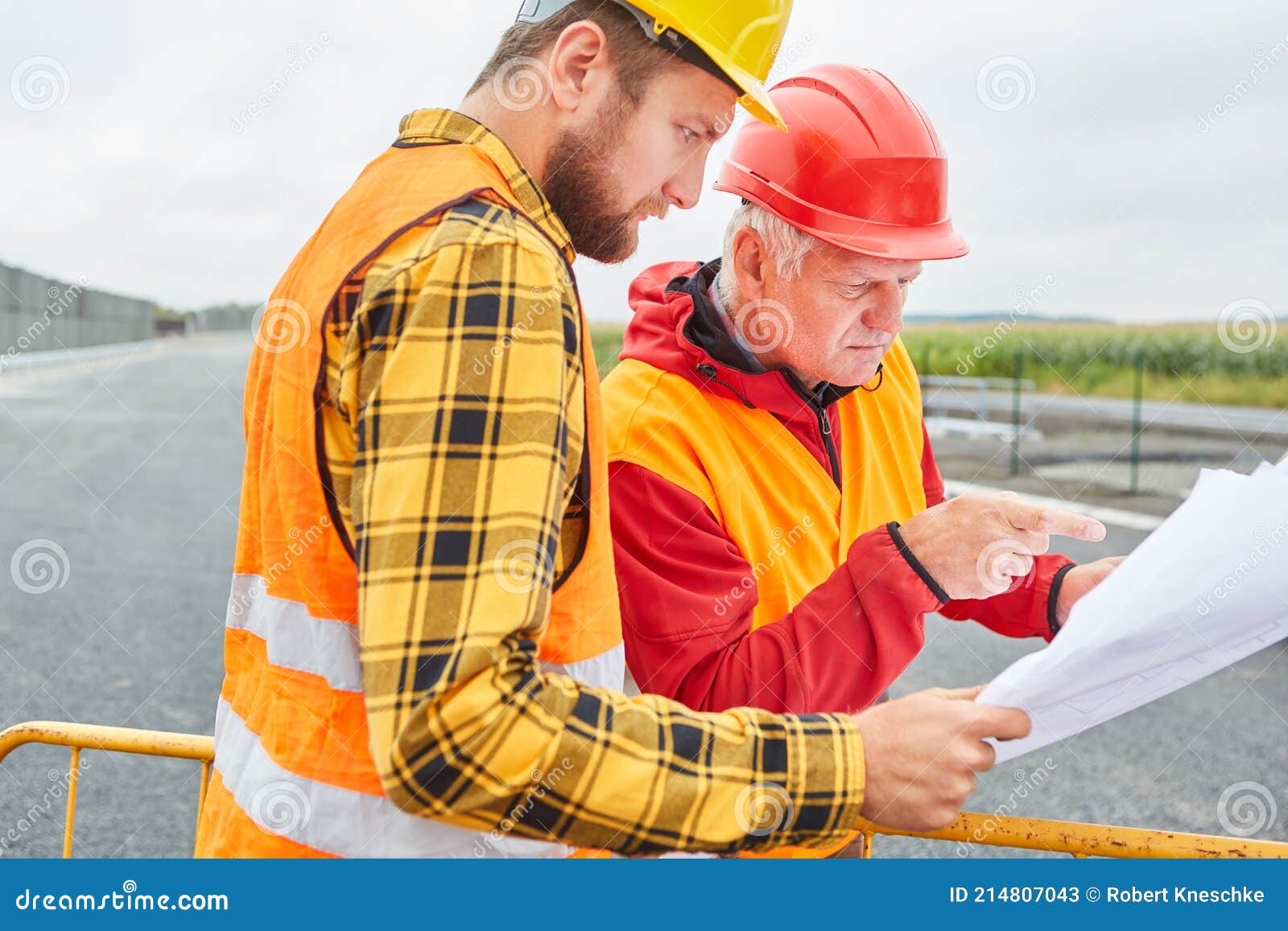 Two Construction Workers with Construction Drawing for the House ...