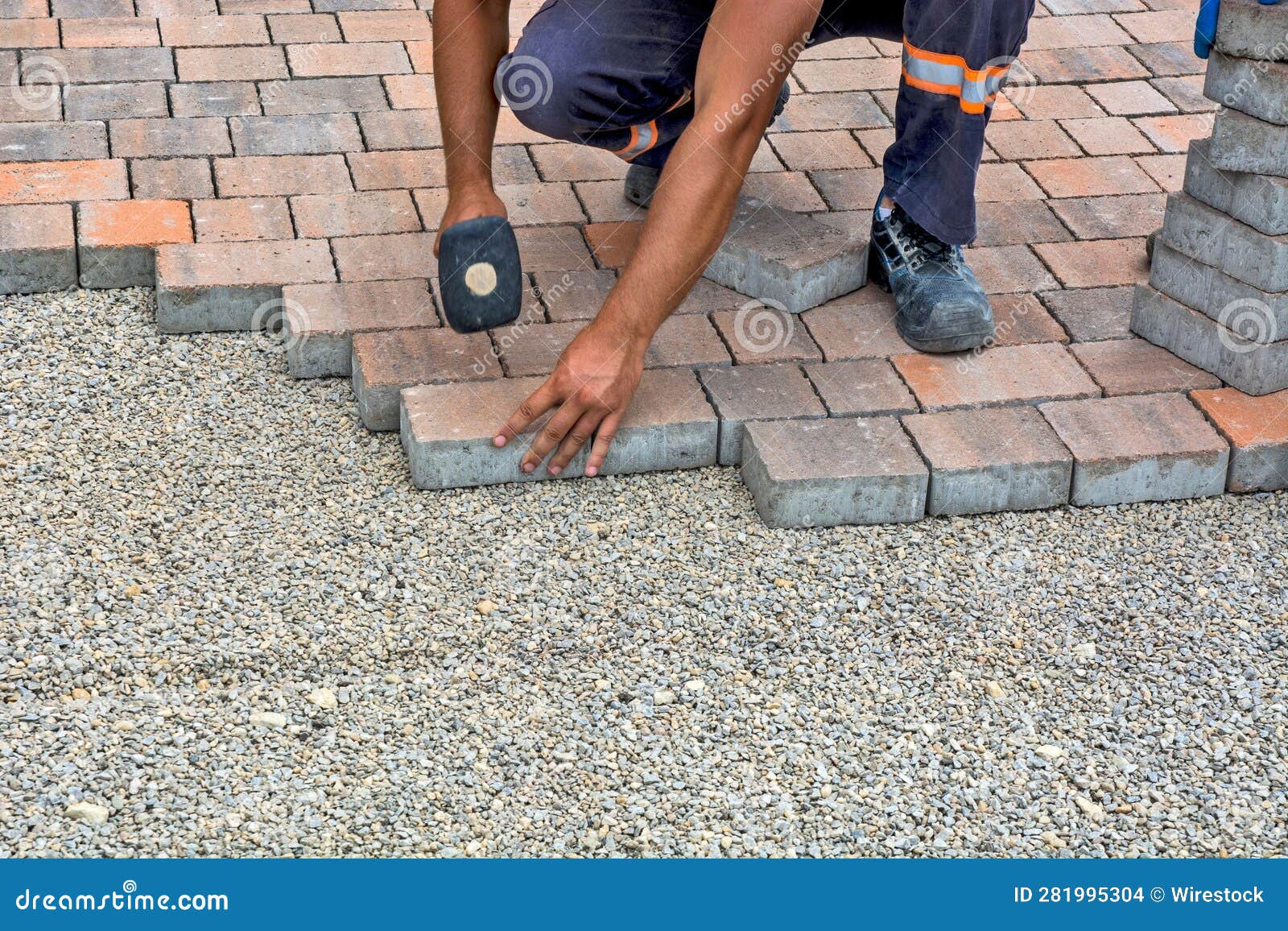 Two Workers Putting the Bricks on the Ground in Front of a Brick ...