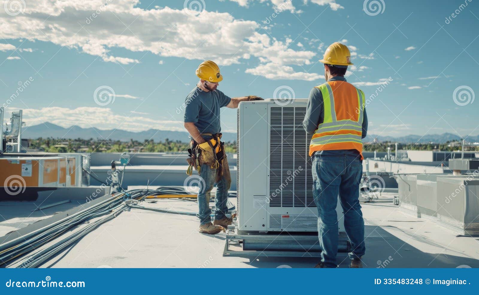 Two Construction Workers on a Roof Inspecting an AC Unit Stock ...