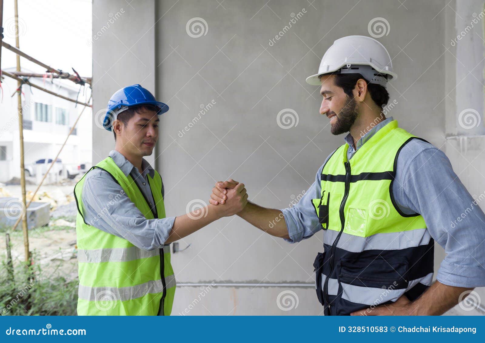 Two Construction Workers in Safety Vest and Helmet Join Hands Together ...