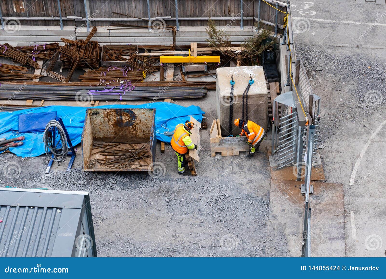 Two Construction Workers at the Sites Storage Area Searching for ...