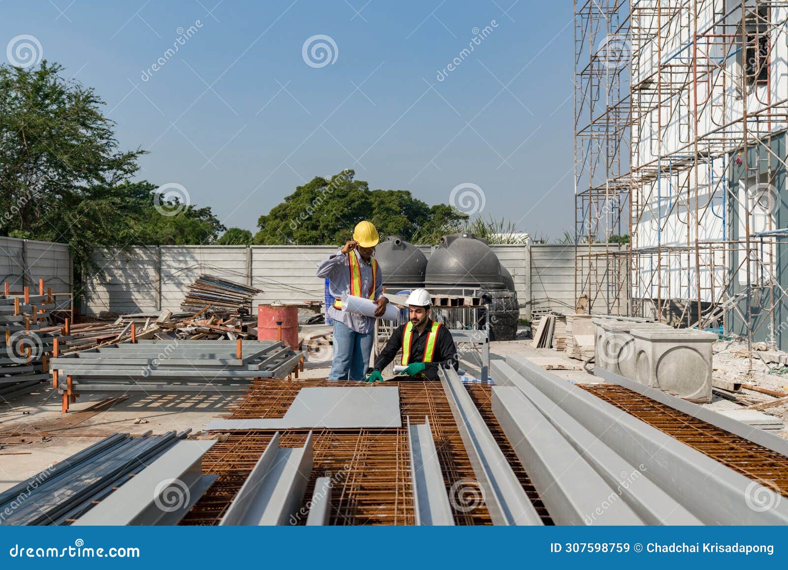 Two Construction Workers are Working on Construction Tasks in Front of ...