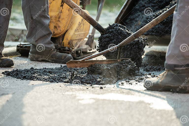 Two Construction Workers Patching Bump in the Road Stock Image - Image ...