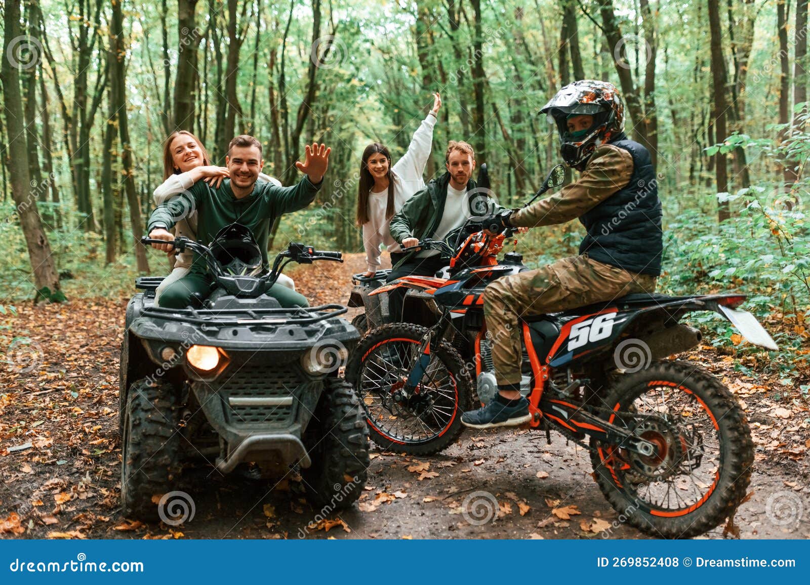 Two Couples on ATV with Man that is on the Bike in the Forest that ...