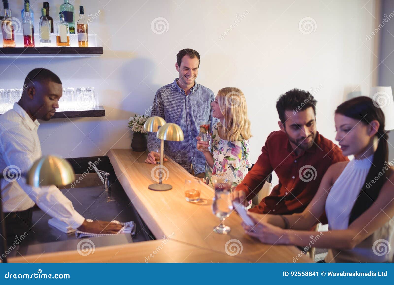 Two Couples Interacting with Each Other while Sitting at Bar Counter ...