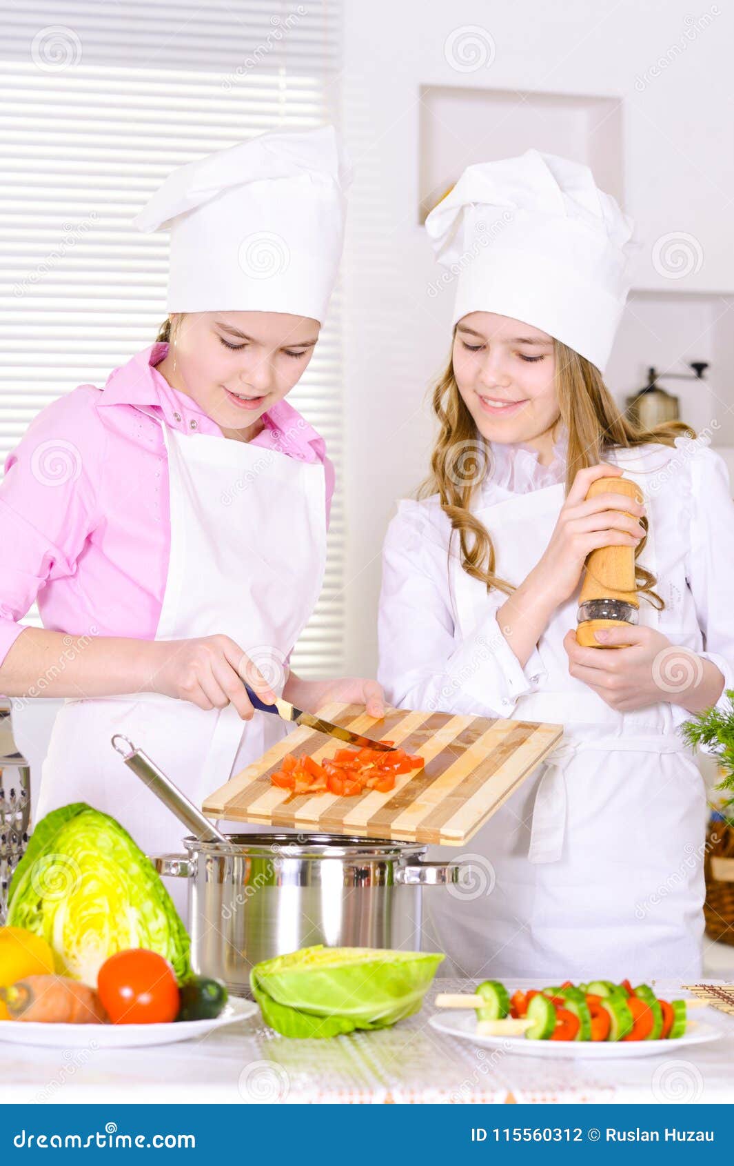 Two cute girls cooking stock photo. Image of children - 115560312