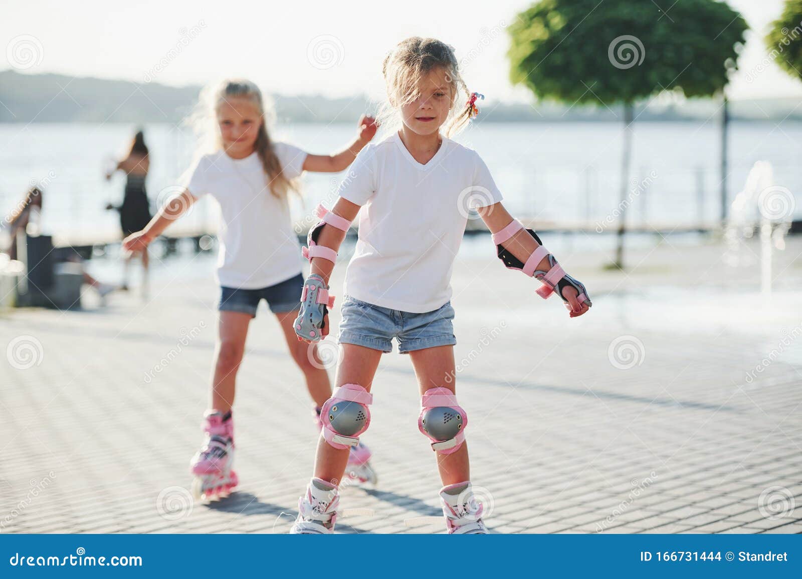 Two Cute Kids Riding by Roller Skates in the Park at Daytime Stock ...