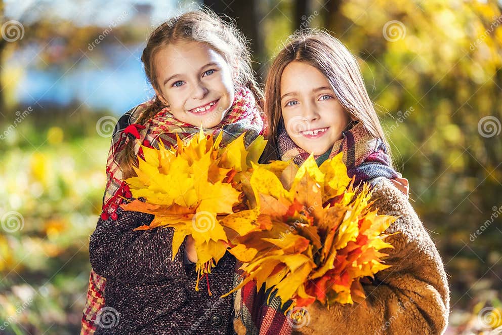 Two Cute Smiling 8 Years Old Girls Posing Together In A Park On A Sunny