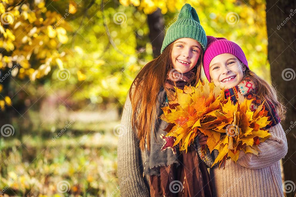 Two Cute Smiling 8 Years Old Girls Posing Together In A Park On A Sunny