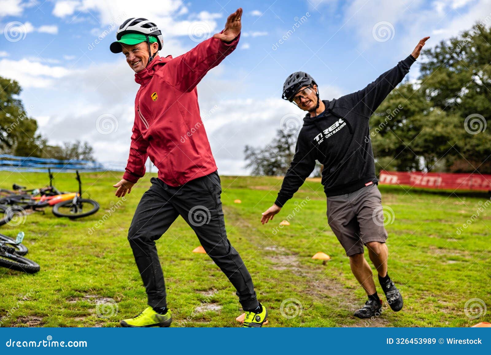 Cyclists Practicing Balance Exercises on a Grassy Field with Their ...