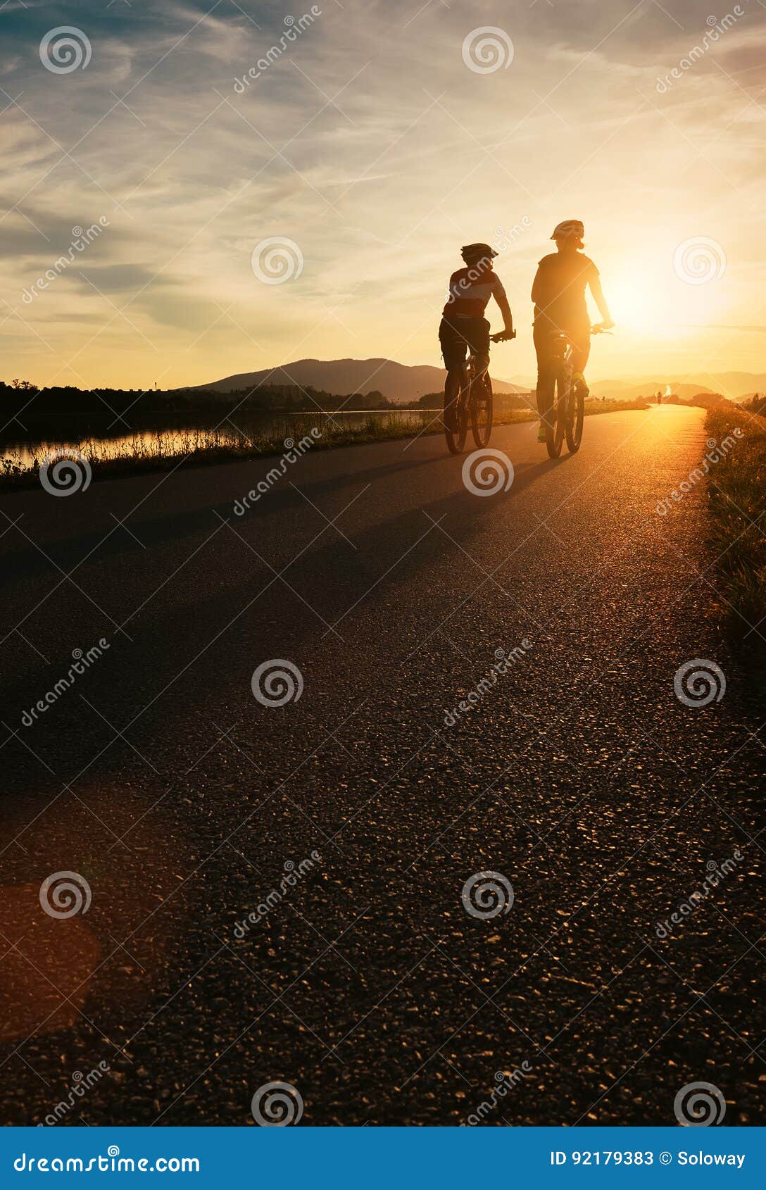 Two Cyclists are on Sunset Road Stock Image - Image of cycle, bicycling ...