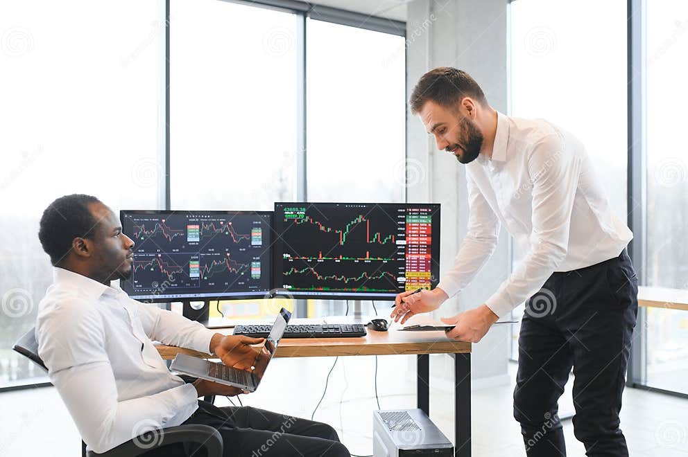 Two Diverse Colleagues Traders Talking To Each Other, Sitting in the ...