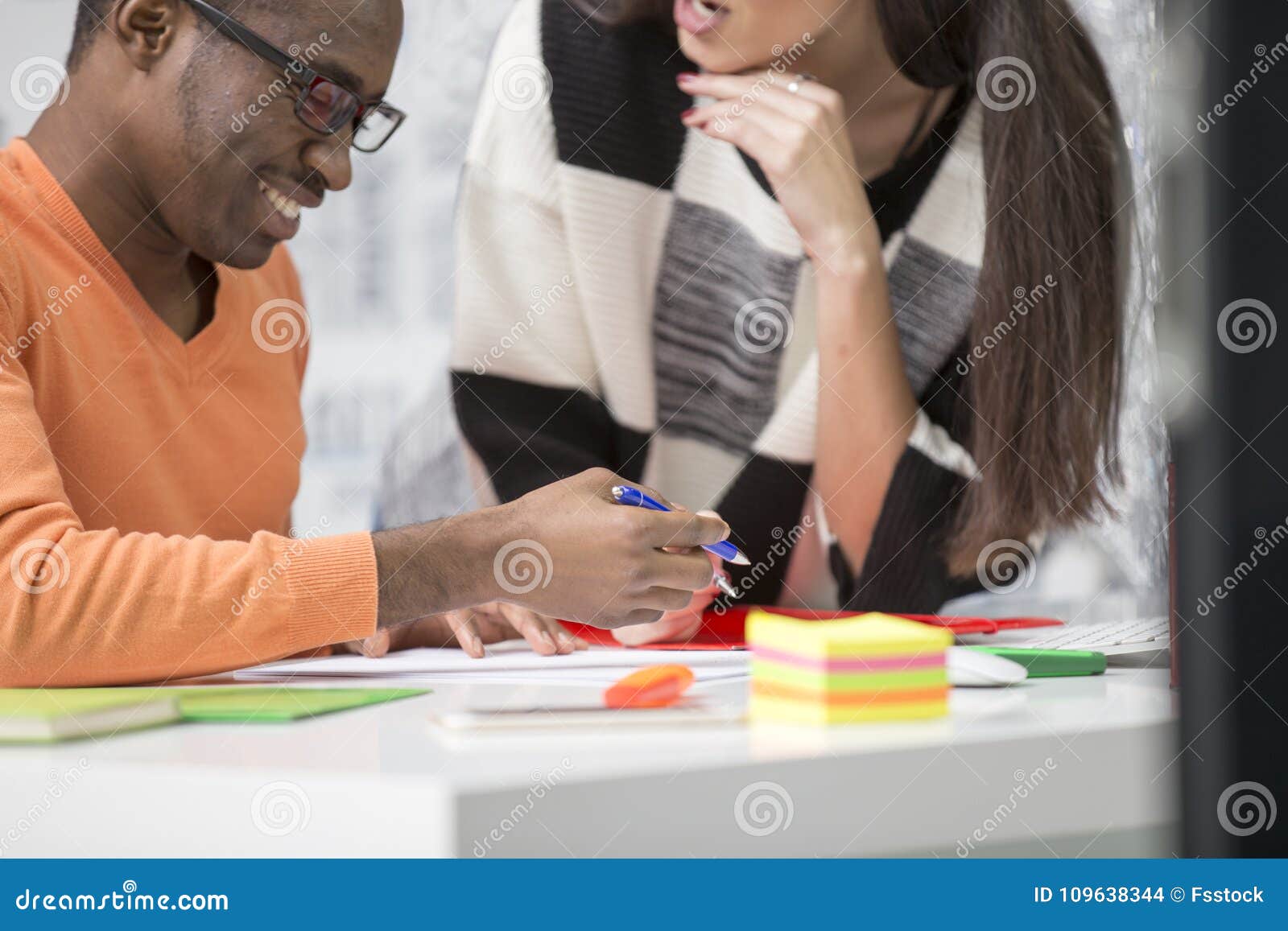 Two Diverse Work Colleagues Smiling and Writing Down Notes while ...