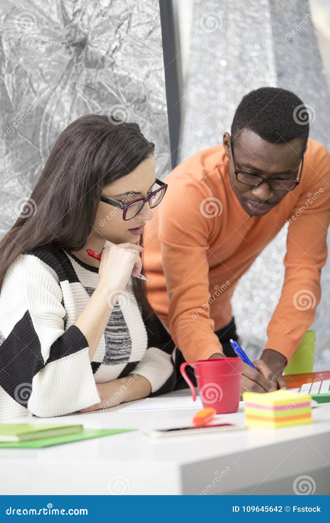 Two Diverse Work Colleagues Smiling and Writing Down Notes while ...