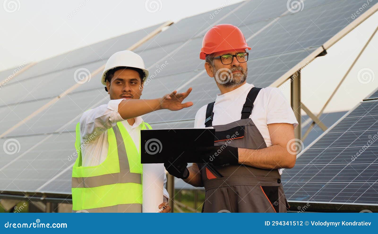 Two Diverse Workers Engineers Talking with Each Other while Holding a ...