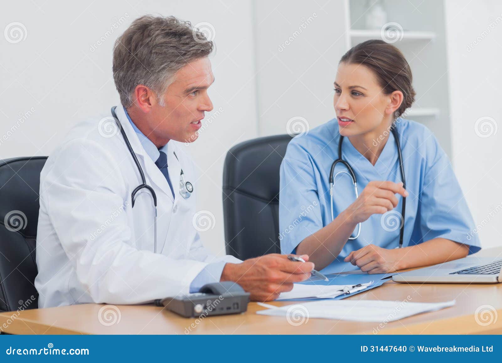 Two Doctors Discussing and Working Together Stock Photo - Image of ...