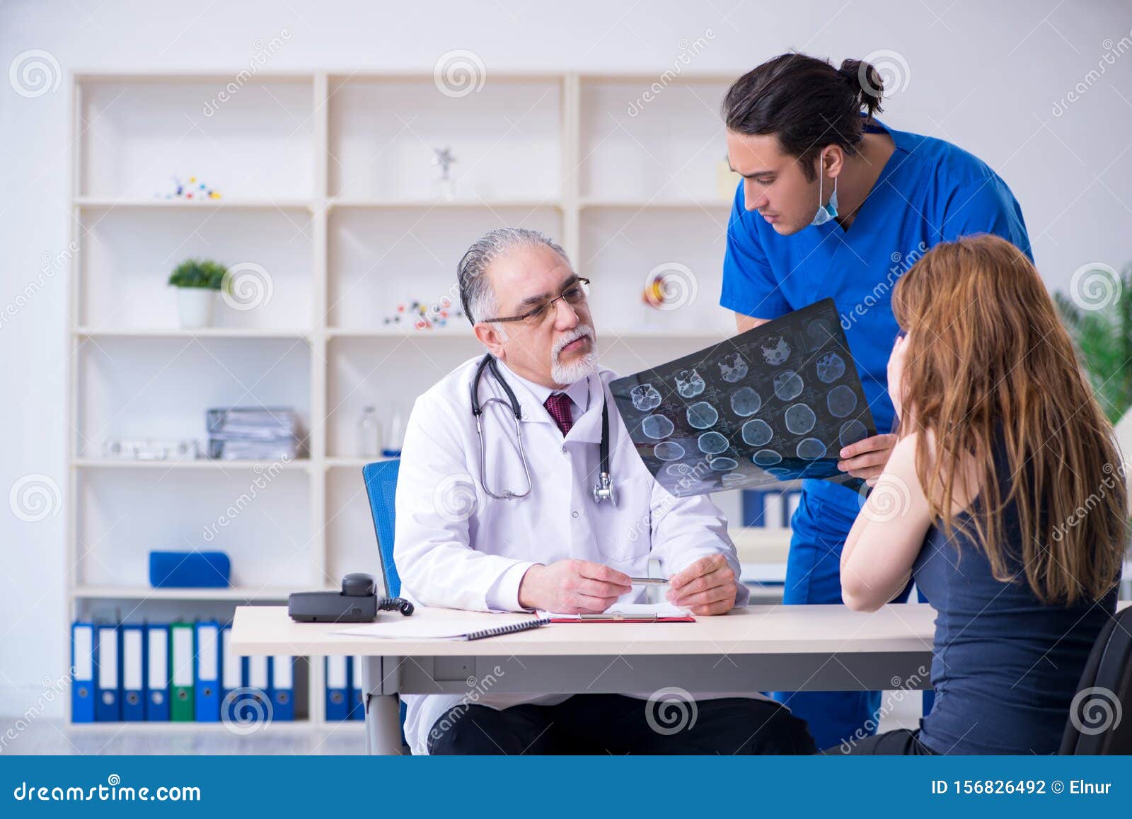 Two Doctors Examining Young Woman Stock Photo - Image of radiologist ...