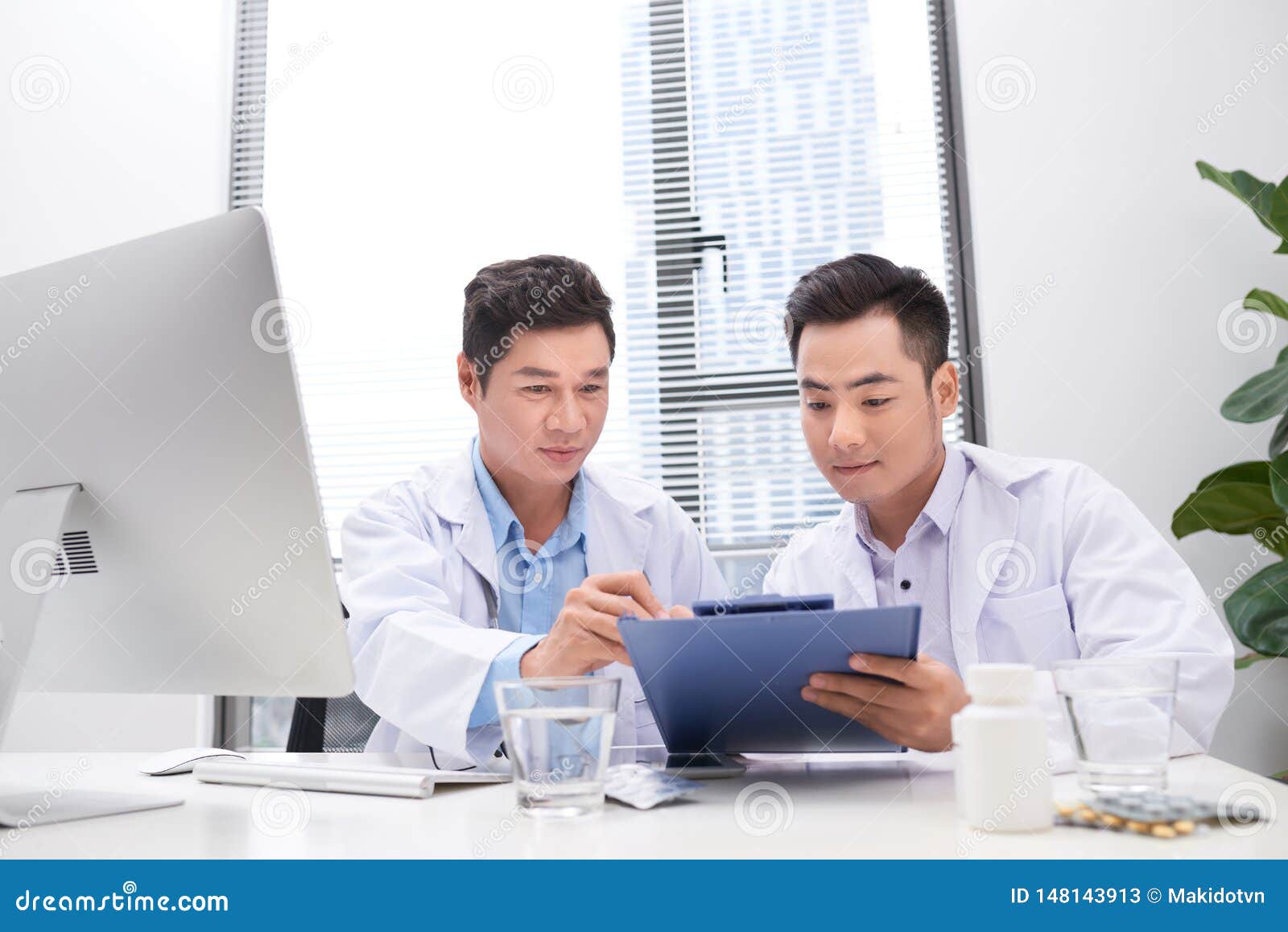 Two Doctors Holding and Talking about Patient on Office Stock Image ...