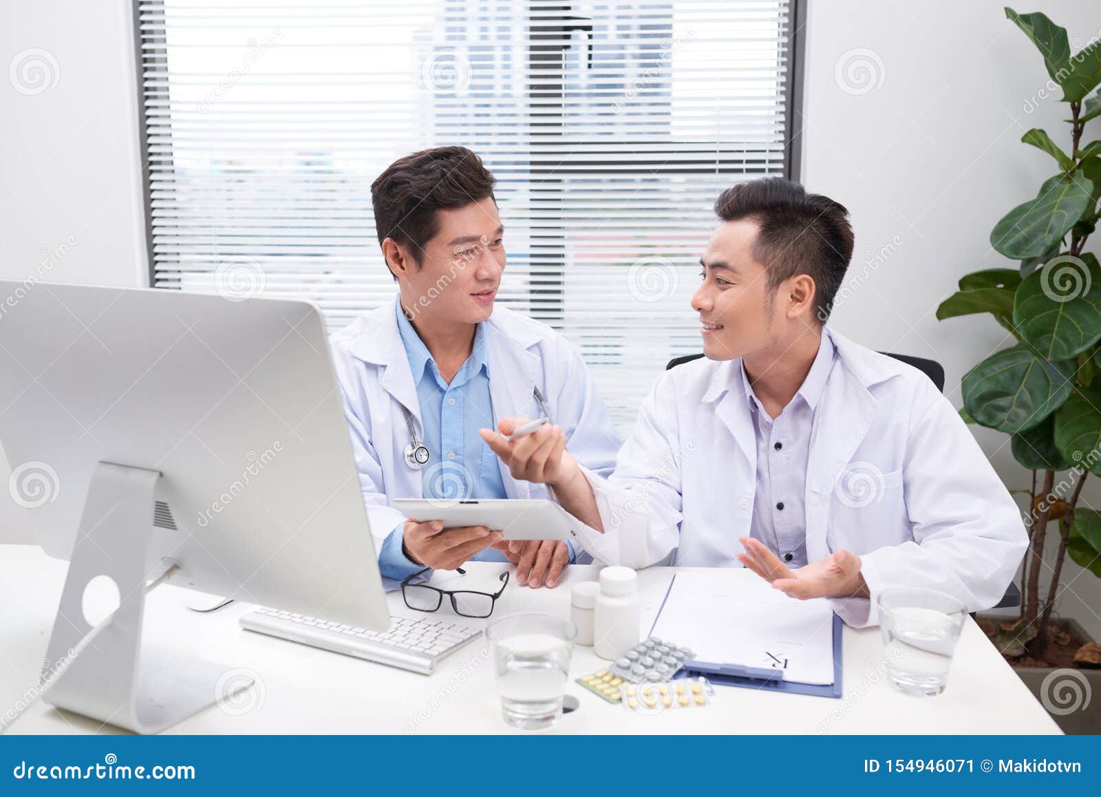 Two Doctors Holding and Talking about Patient on Office Stock Image ...