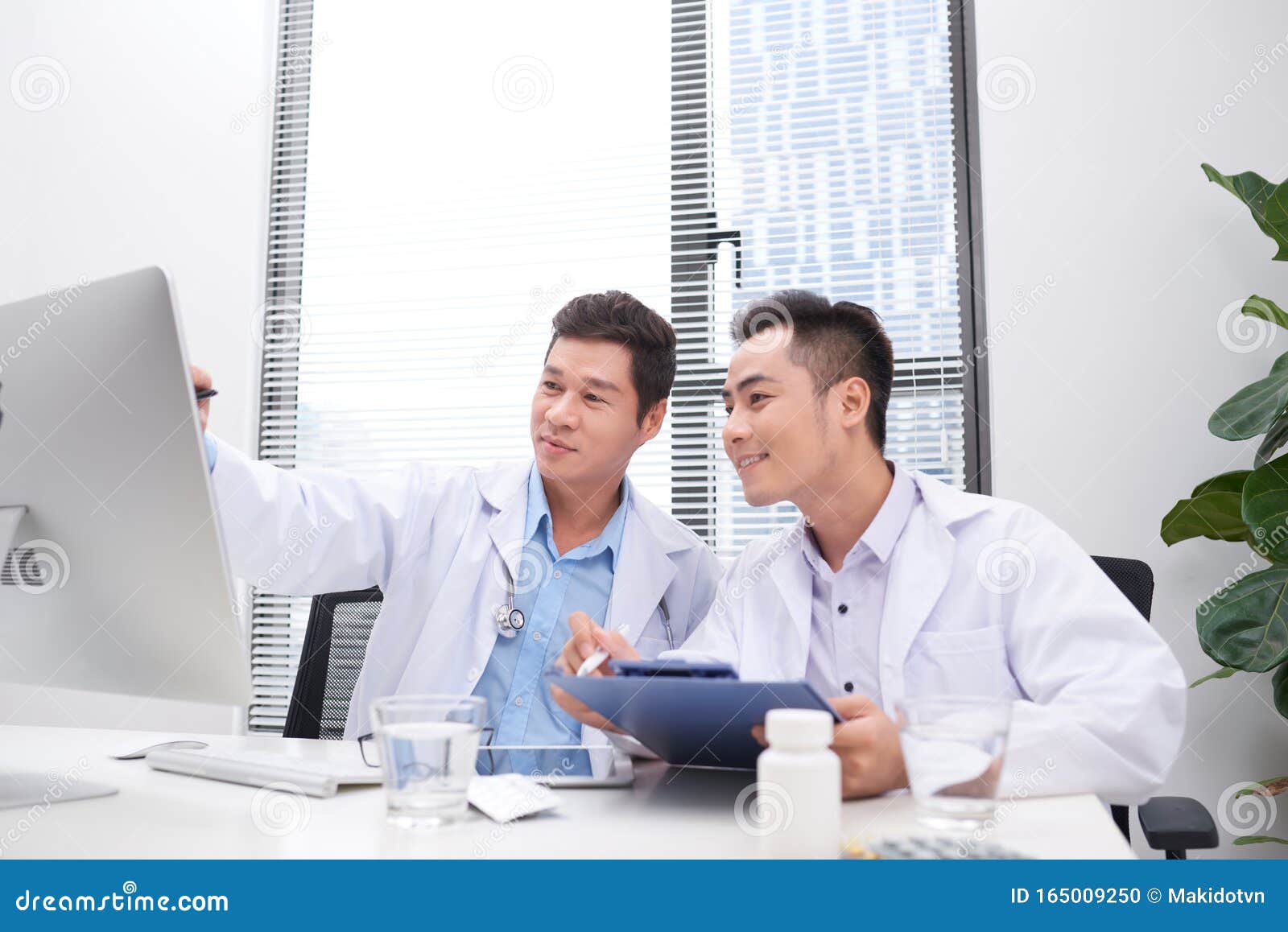 Two Doctors Holding and Talking about Patient on Office Stock Photo ...