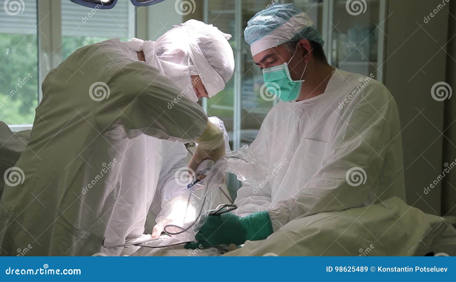 Two Doctors in Protective Clothing Performing Surgery Use Sterilized ...