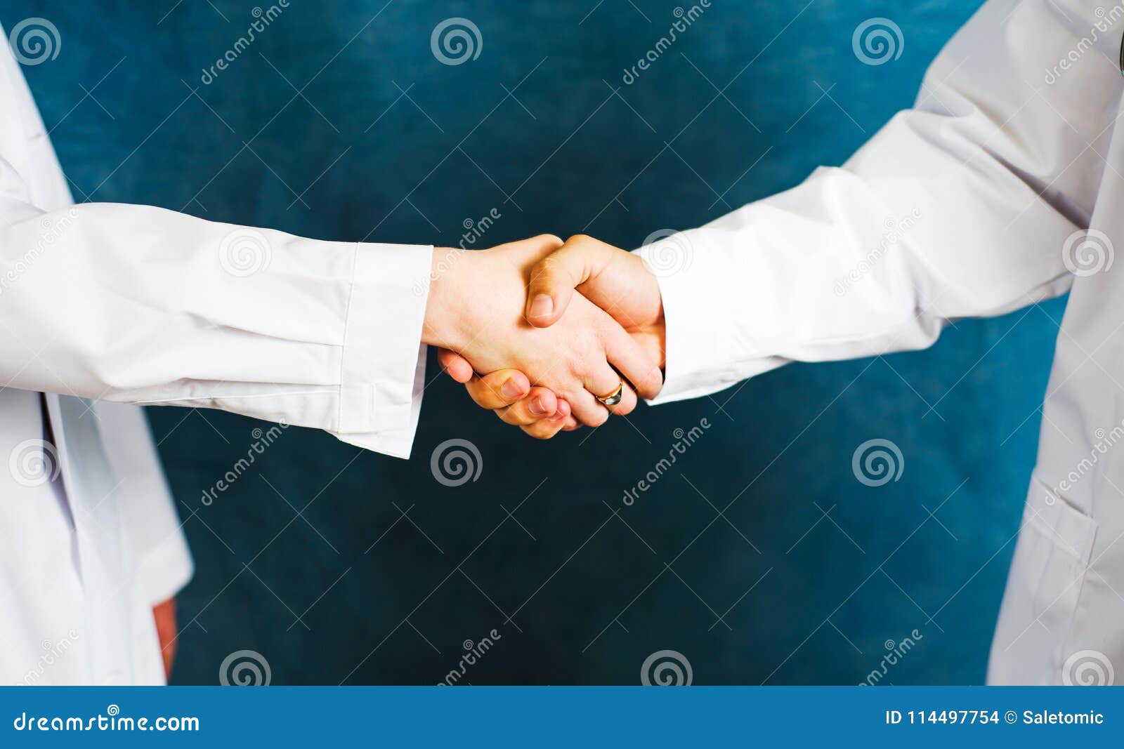 Doctors Shaking Hands On Light Blue Background Stock Photography ...