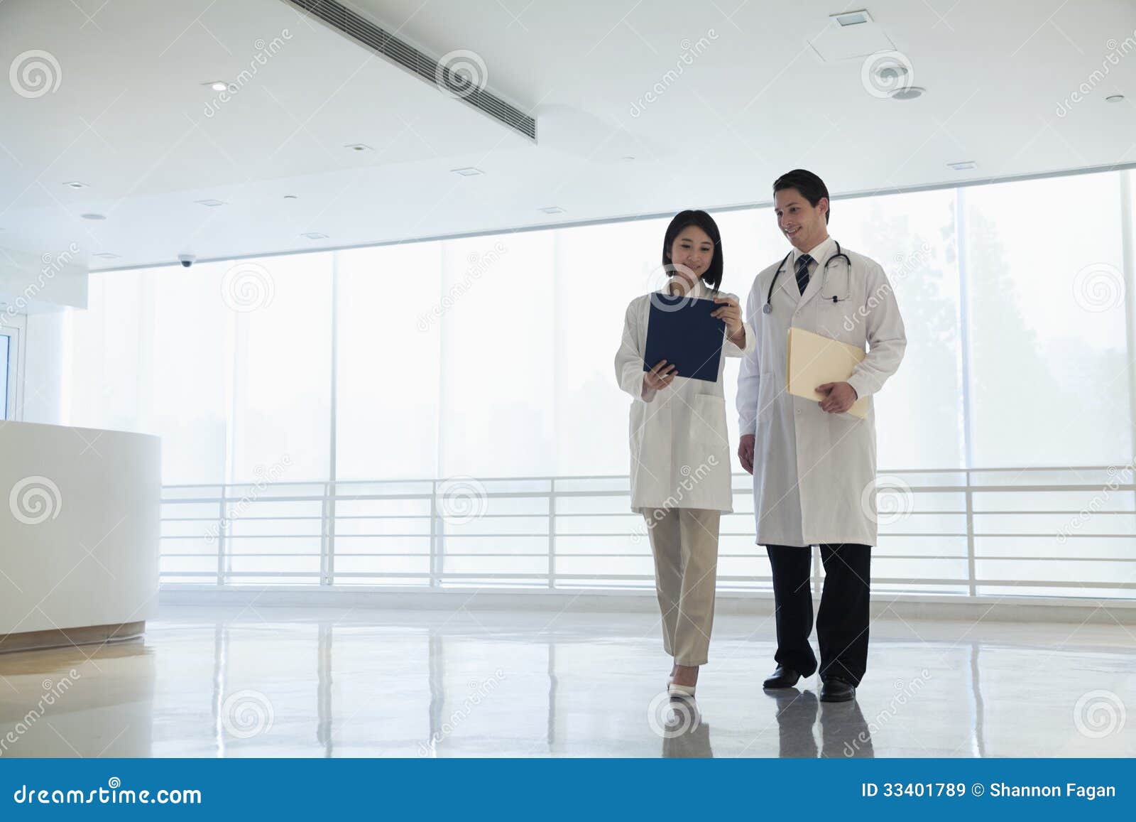 Two Doctors Standing and Looking Down at a Document in the Hospital ...