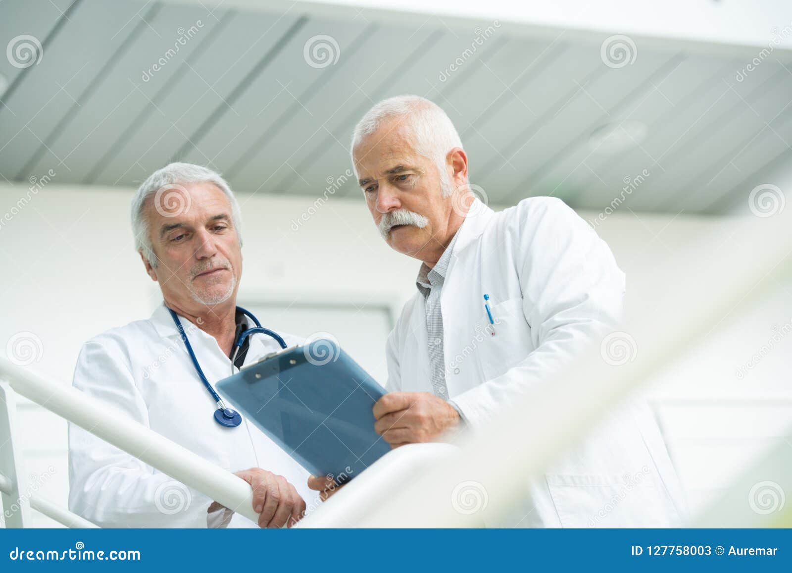 Two Doctors Talking As they Walk through Modern Hospital Stock Image ...