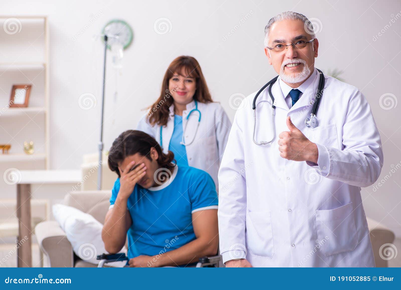 Two Doctors Visiting Sick Young Man at Home Stock Image - Image of ...