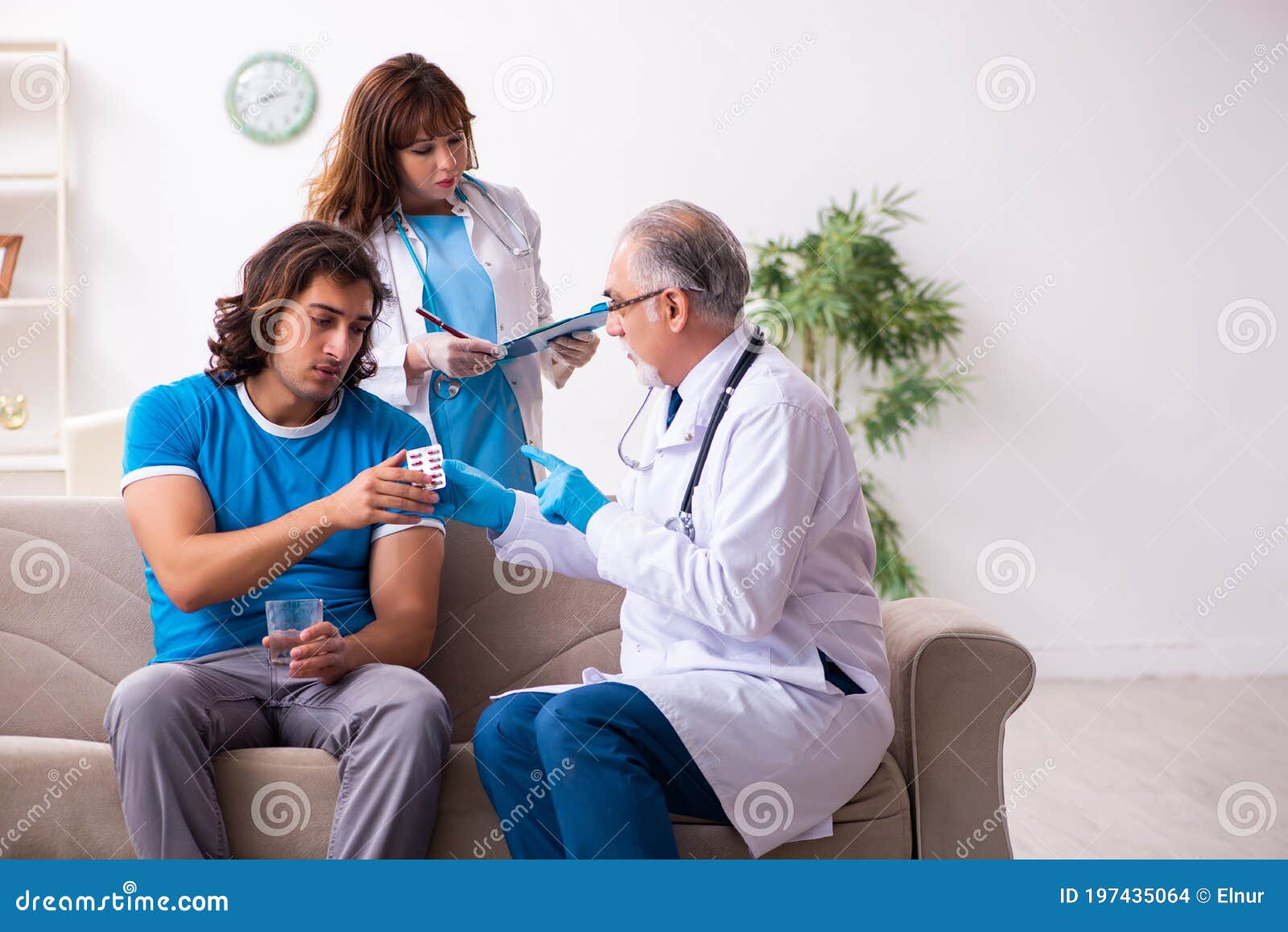Two Doctors Visiting Sick Young Man at Home Stock Photo - Image of ...