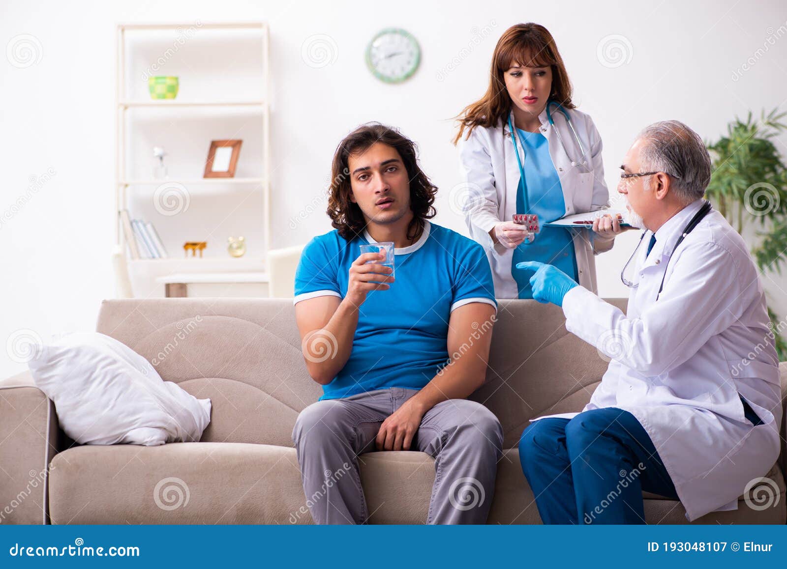 Two Doctors Visiting Sick Young Man at Home Stock Image - Image of ...