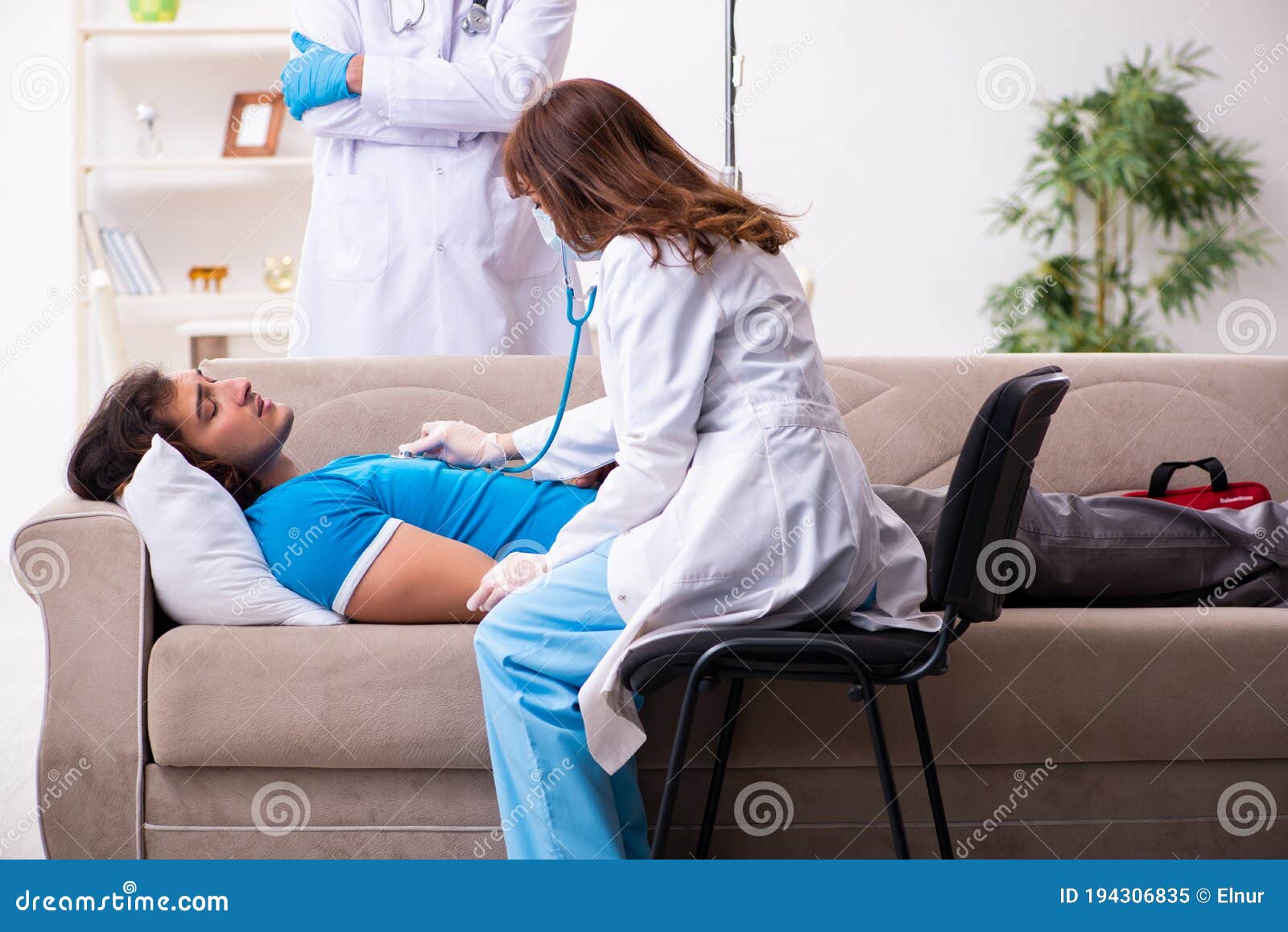 Two Doctors Visiting Sick Young Man at Home Stock Image - Image of home ...