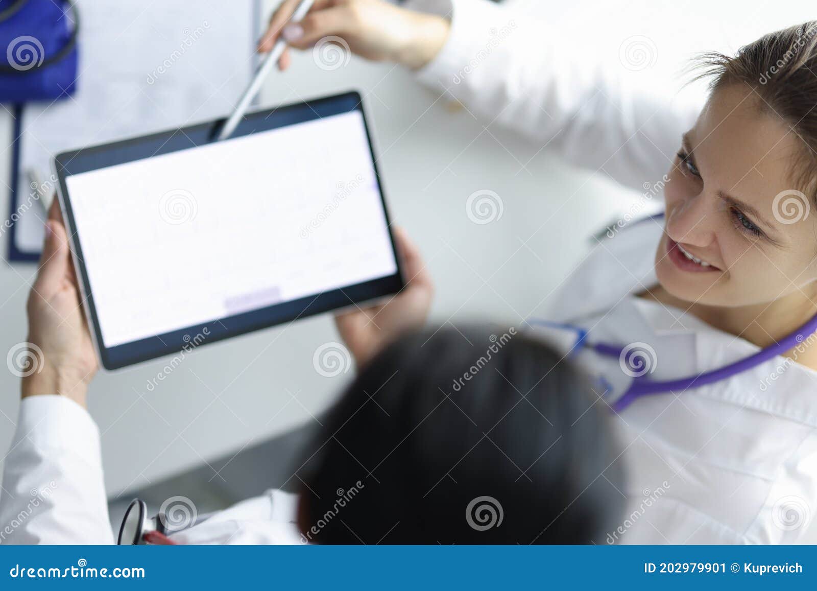 Two Doctors at Workplace are Looking at Tablet. Stock Image - Image of ...