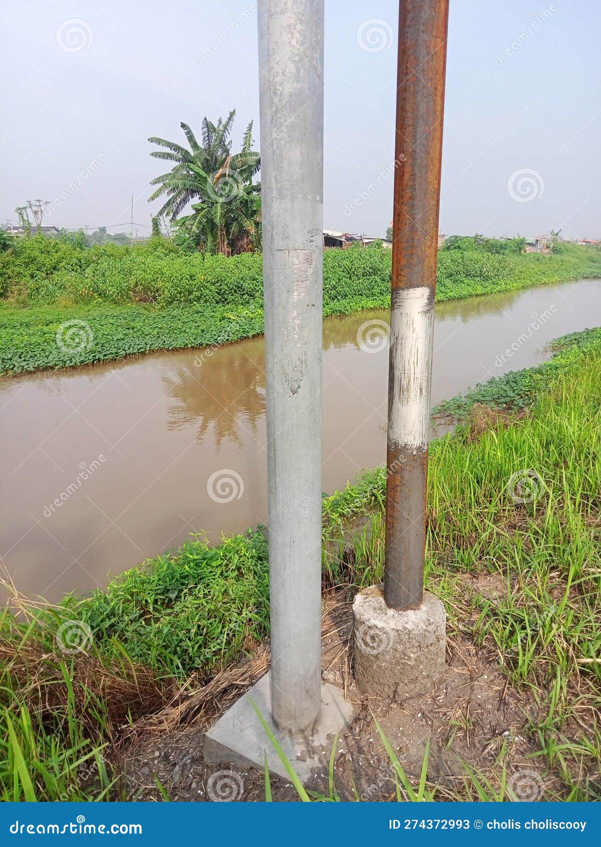 Two Electric Poles by the Brown River Water Stock Image - Image of ...