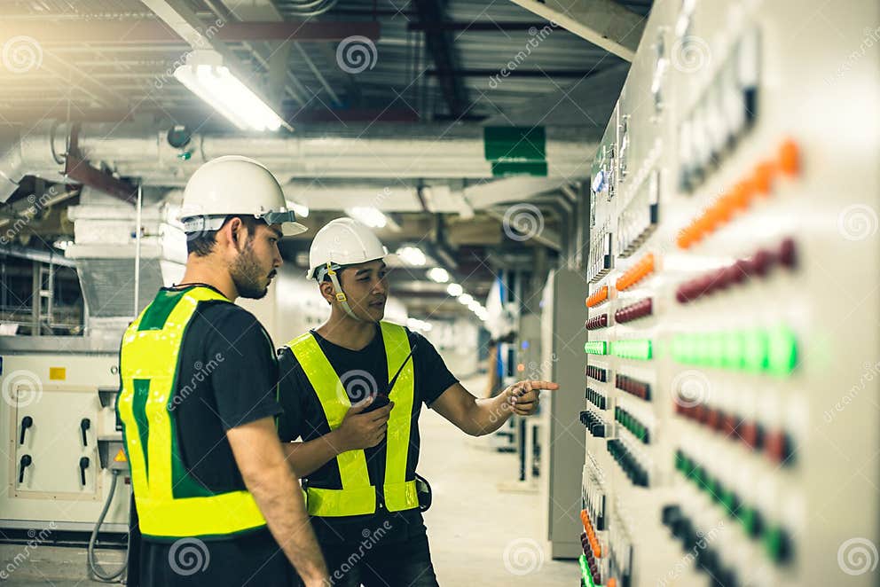 Two Electrical Engineer Team Working Front Control Panel. Stock Photo ...