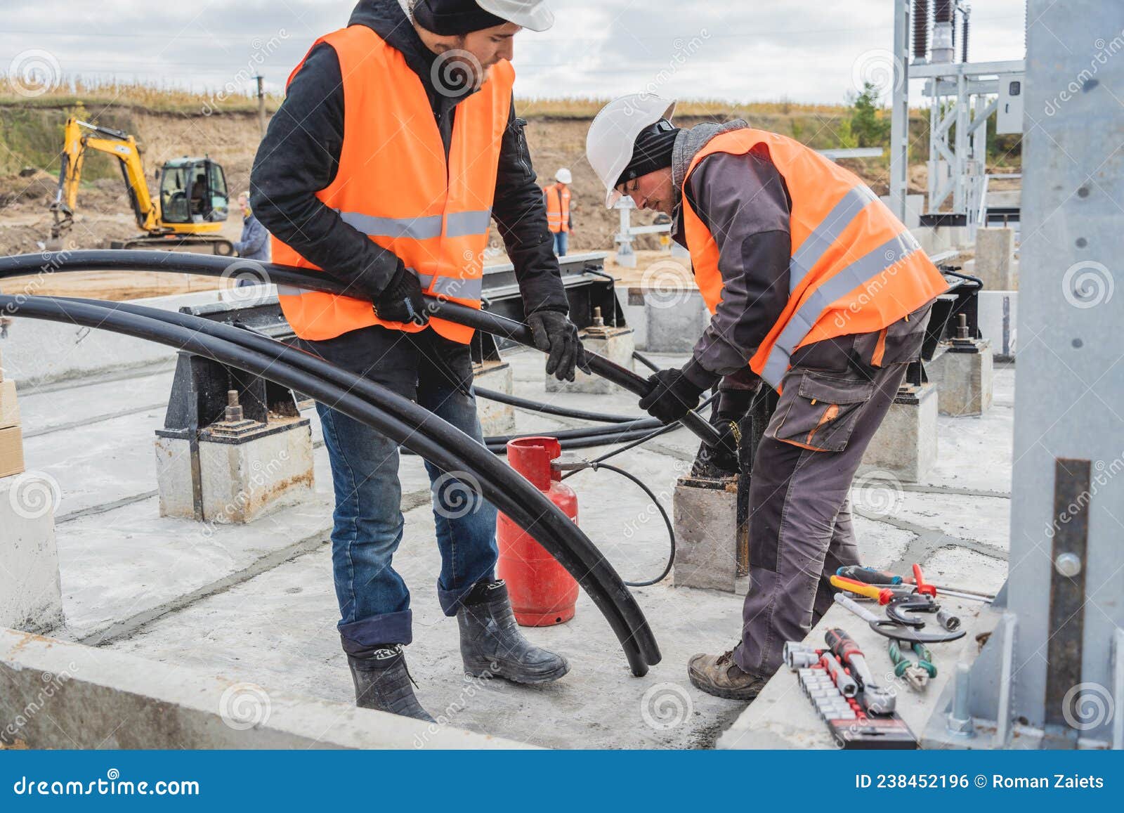 Two Electrician Builder Workers Installing High-voltage Cable Stock ...