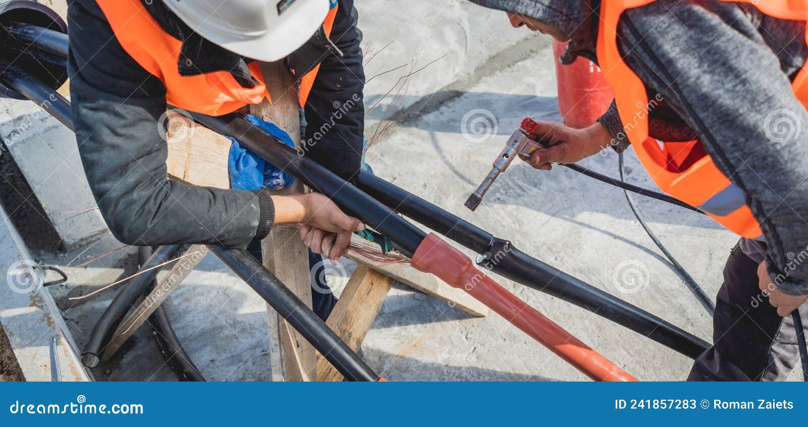 Two Electrician Builder Workers Installing High-voltage Cable Stock ...