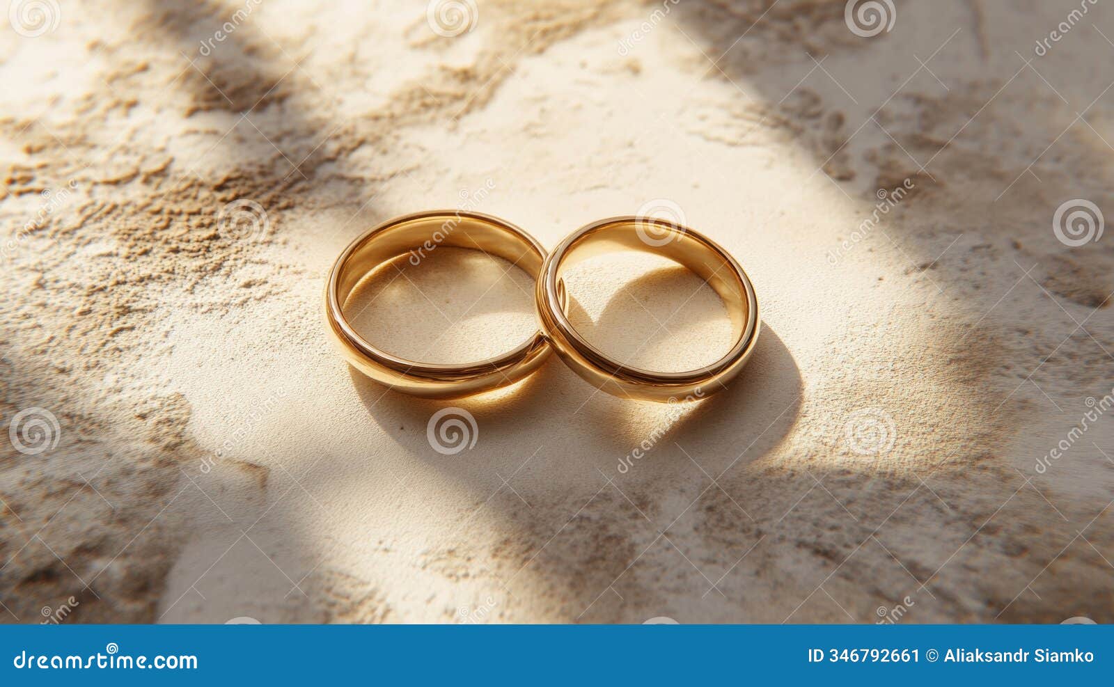 Two Elegant Gold Wedding Rings on Textured Surface with Soft Light ...