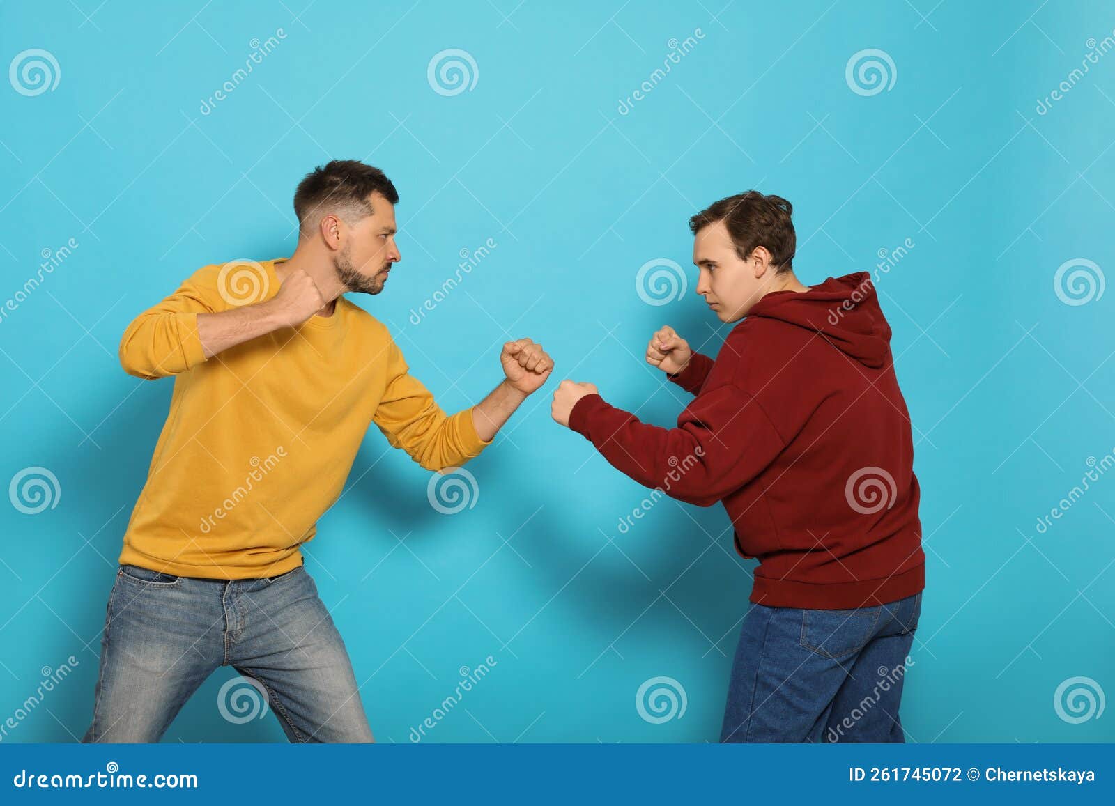 Two Emotional Men Fighting on Light Blue Background Stock Photo - Image ...