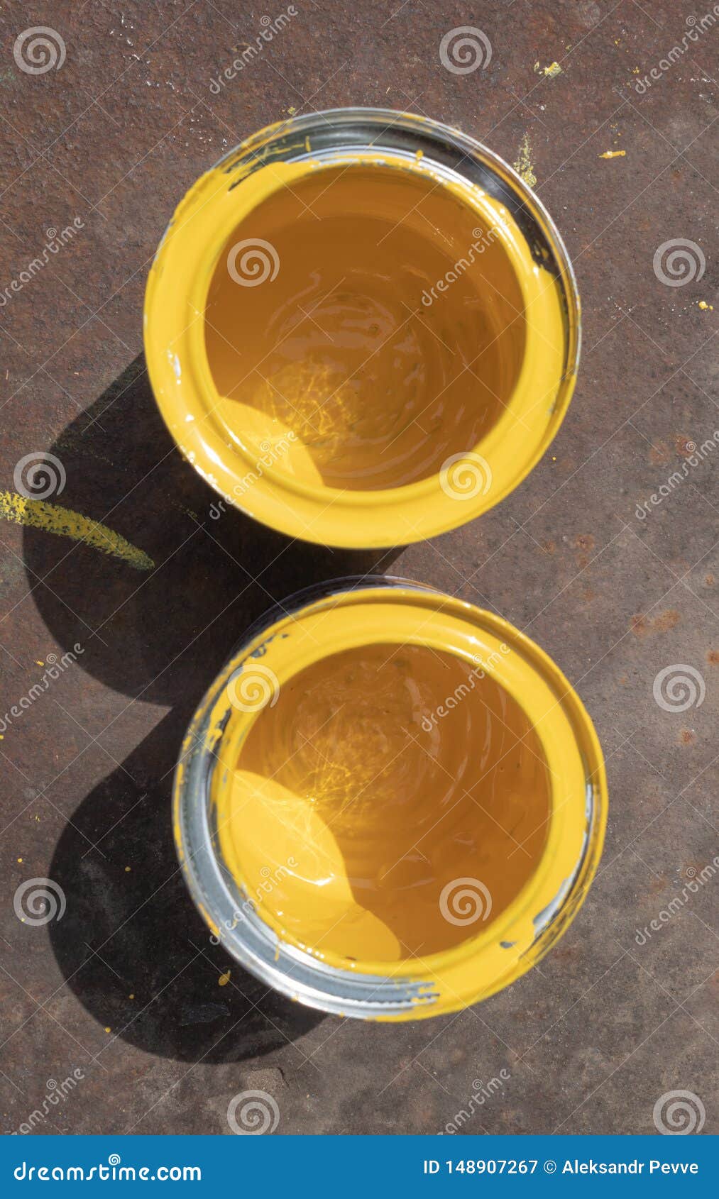 Two Empty Yellow Paint Cans with Smudges Stand on a Rusty Iron Sheet ...
