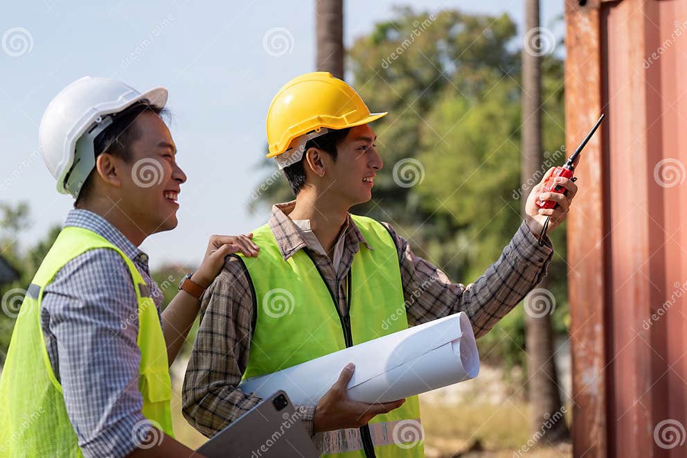 Engineers Collaborating on Construction Plans Outdoors with Blueprints ...